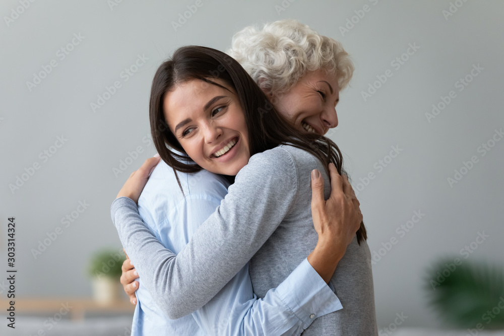 Happy Young Granddaughter Embracing Hugging Old Retired Grandmother
