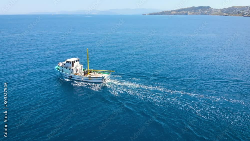 A small fishing boat in the afternoon goes at full speed into the open ...