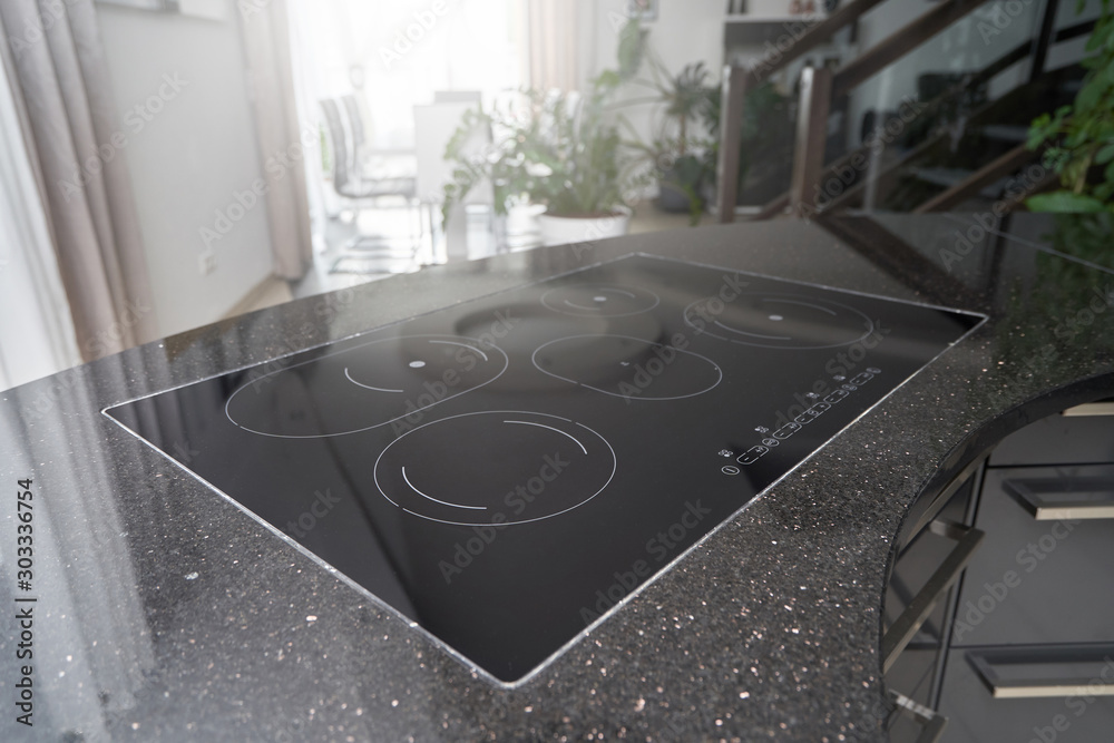 Built-in induction cooker with a black glass surface in the kitchen ...