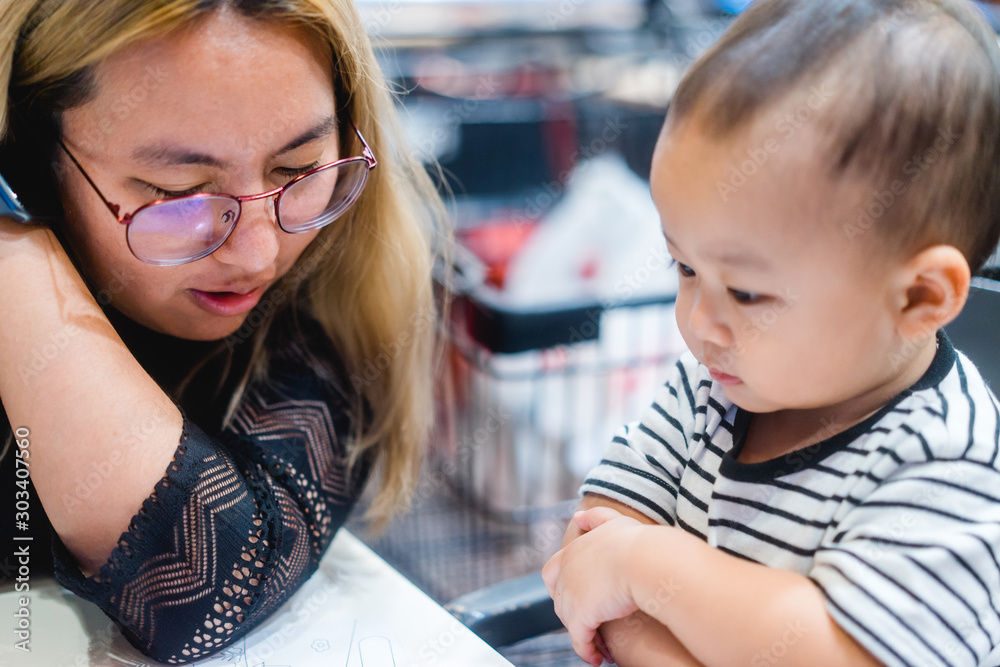 Asian Mother and her baby son using smartwatch video call camera in ...