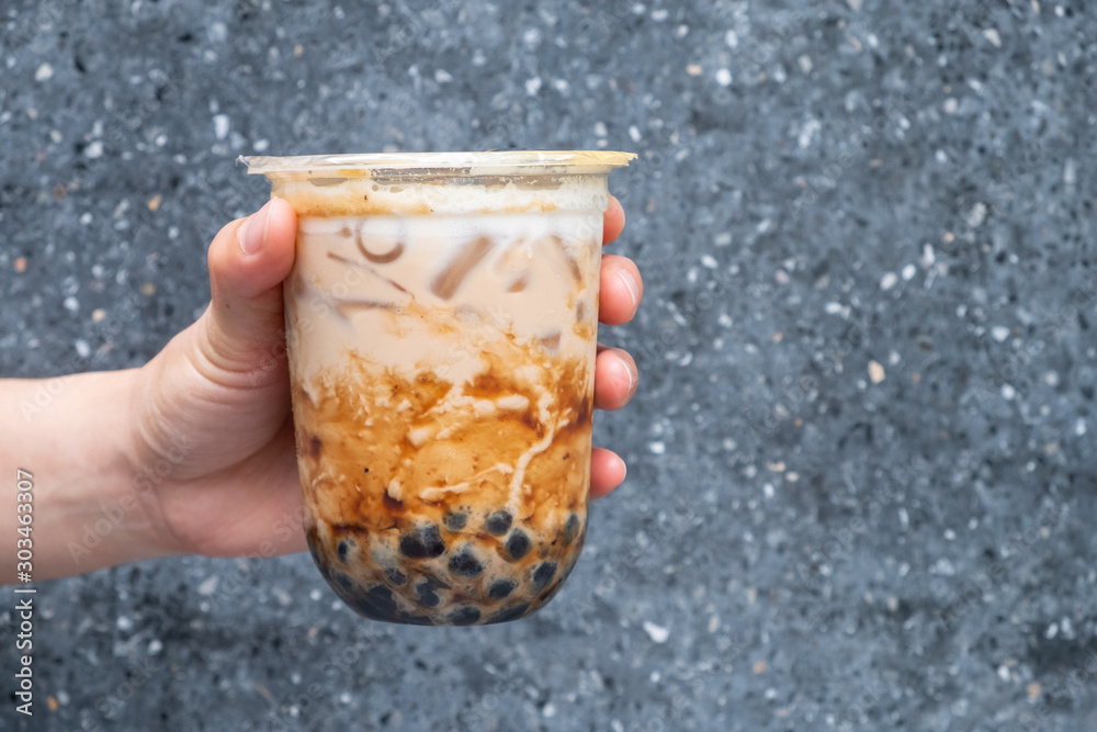 Cropped shot of someone hand holding a cup of iced Bubble milk tea ...