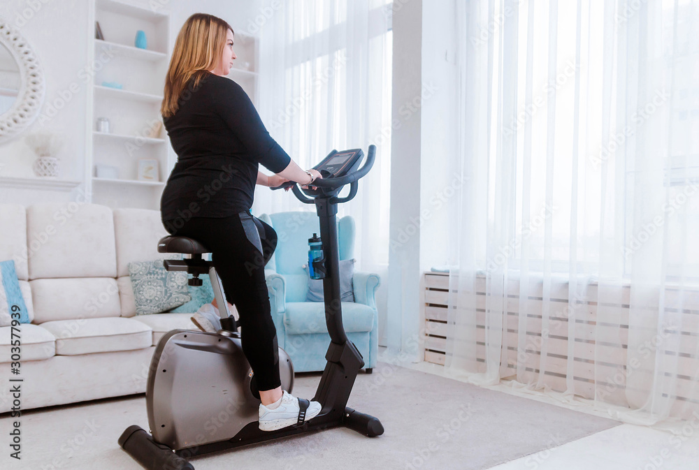 Model - a fat woman, at home engaged in a stationary bike. Stock Photo ...