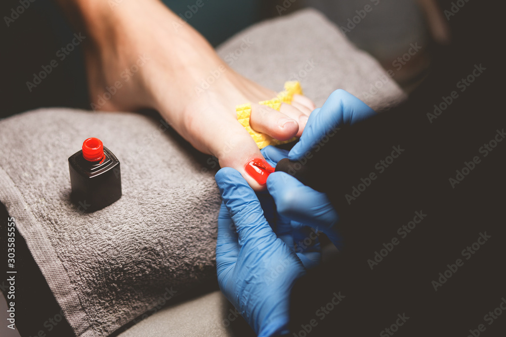 Master does pedicure for client. Pedicure process. Girl draws toenails ...