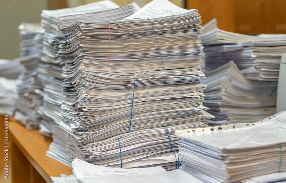 bundles bales of paper documents. stacks packs pile on the desk in the ...