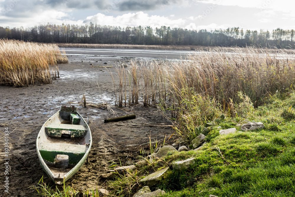Autumn. Big pond for breeding fish without water. A boat lies at the ...