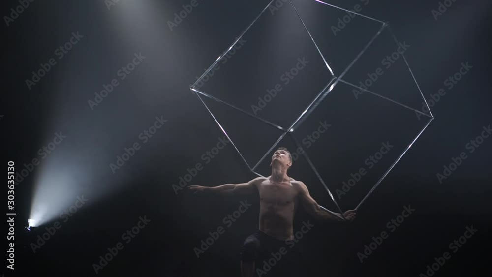 circus male muscular performer making tricks with juggling cube props ...
