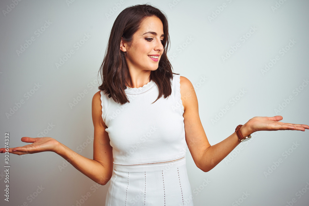 Young beautiful woman wearing dress standing over white isolated ...