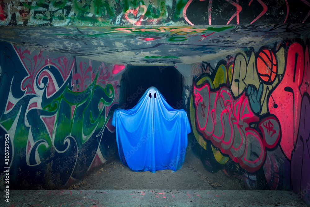Blue sheet ghost posing in front the tunnel with vivid graffiti ...