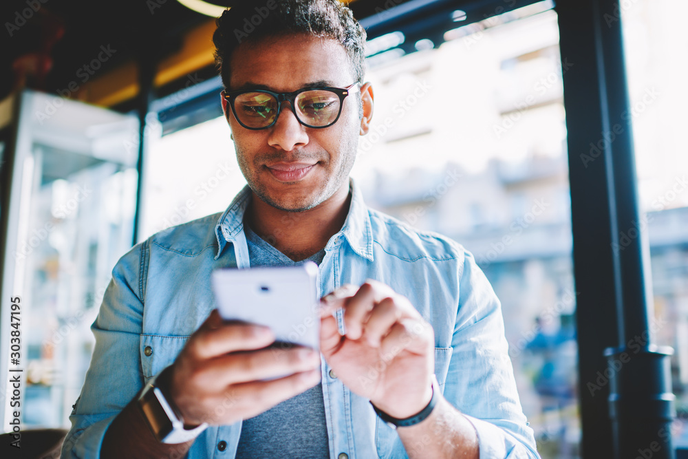 Hindu hipster guy typing text message on smartphone device.Young man ...