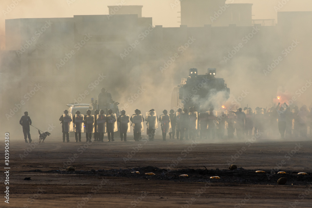Military police riot response to a protest with tear gas, smoke, fire ...