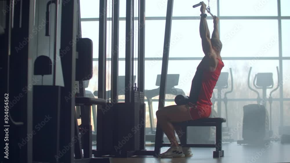 Shoulder pull down machine. Man working out lat pulldown training at ...