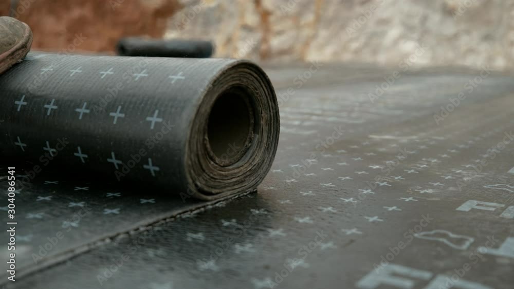 SLOW MOTION, CLOSE UP, DOF: Unrecognizable worker rolls out black tar ...
