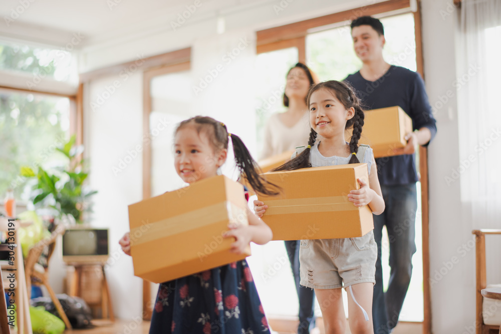 Young Asian family with daughter holds carton and walking in to a new ...