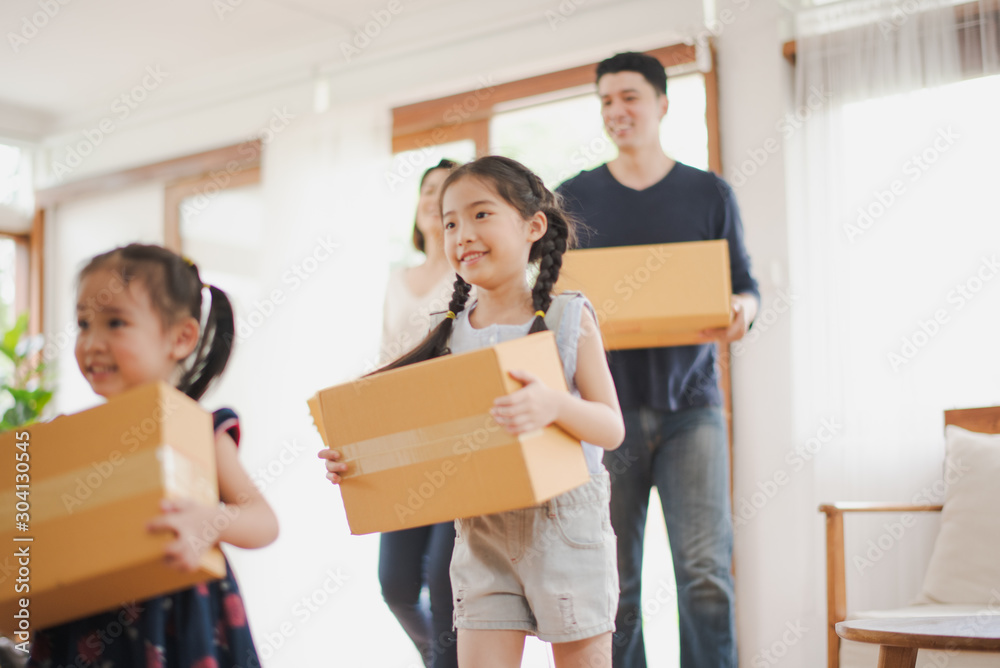 Young Asian family with daughter holds carton and walking in to a new ...
