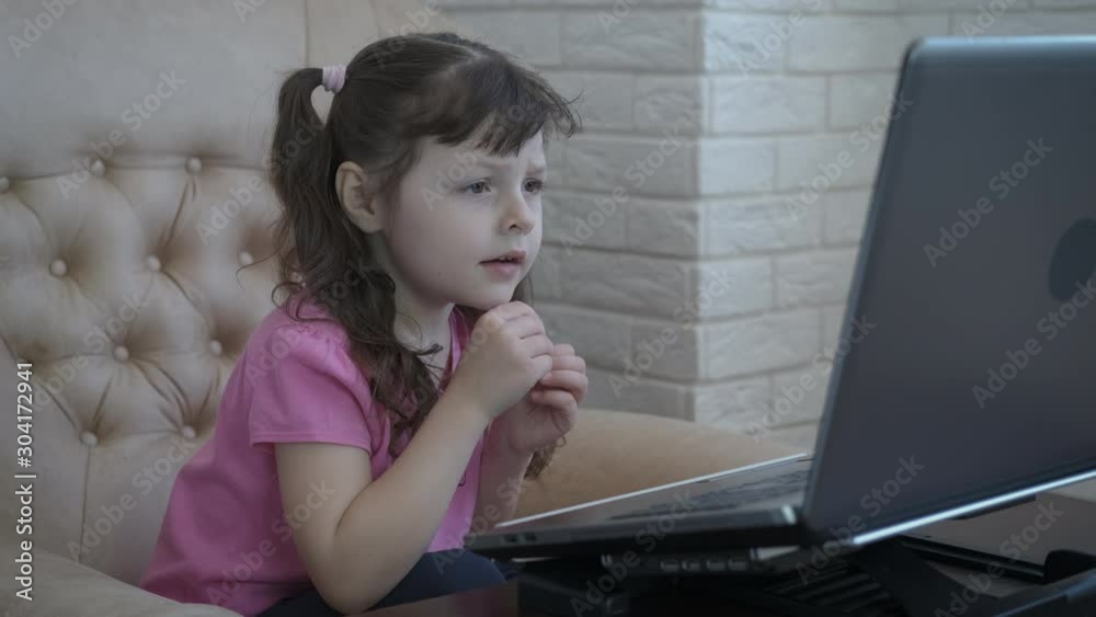 Horror on computer. The little girl is frightened by what she sees in ...