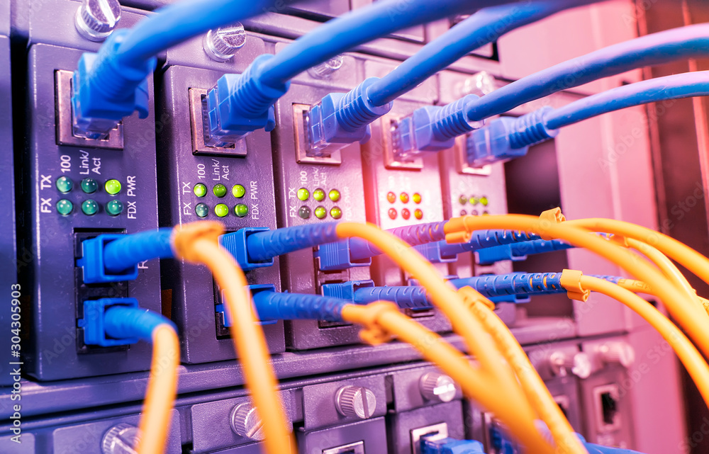 Fiber Optic cables connected to an optic ports and Network cables ...