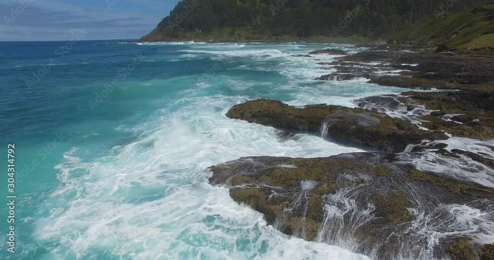 Slow motion capture of sea water bursting forth from a sinkhole on the coastline of the Pacific ...