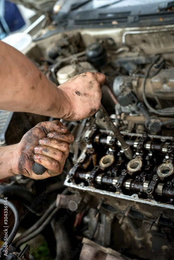 A man does a broach of the head. Makes car repair, engine ...