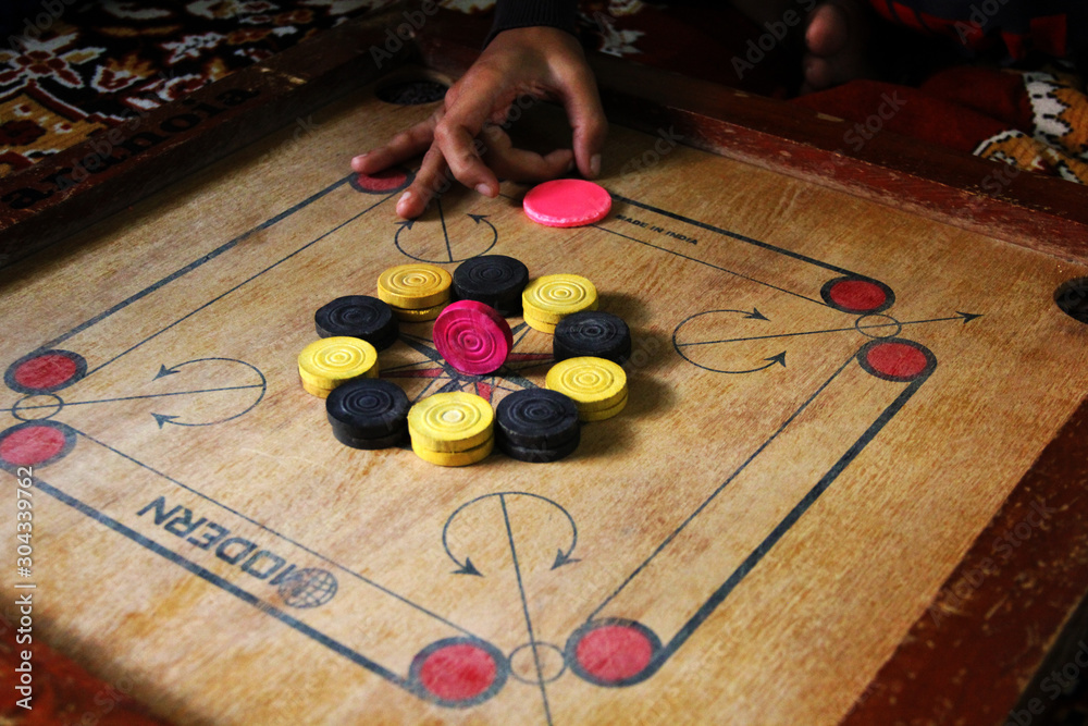 A game of carrom with pieces carrom man on the board carrom.Carom board ...