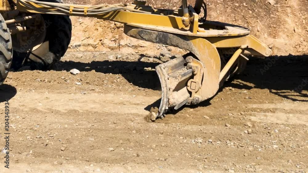 Close-up of moldboard planning road surface. Blade of motor grader ...