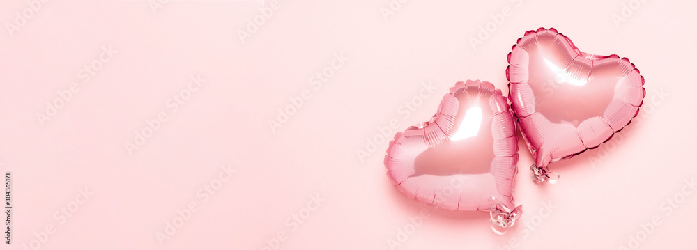 Two pink air balloons in the shape of a heart on a pink background ...