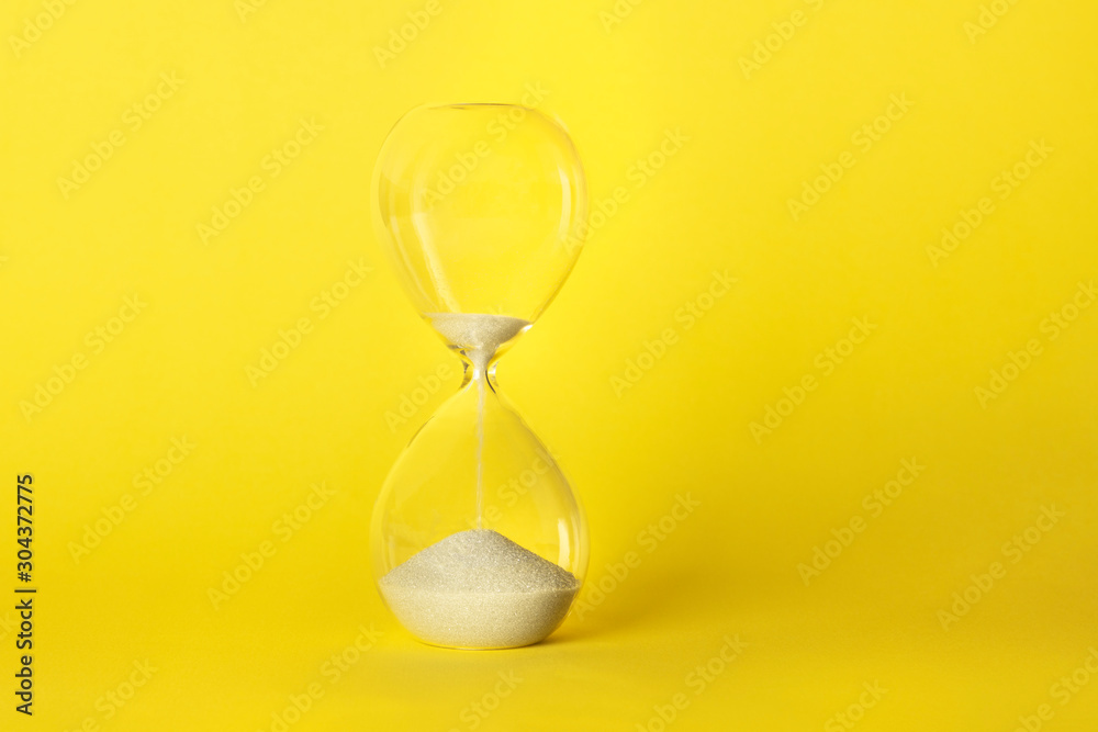 Time is running out concept. An hourglass with sand falling through, on ...