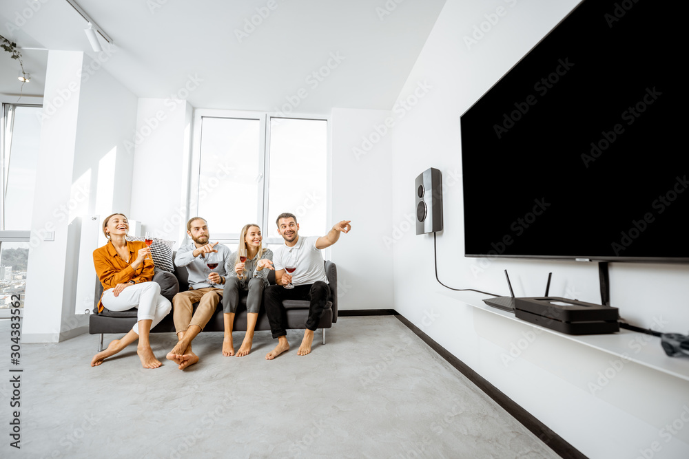 Group of a young friends watching television, hanging out together on ...