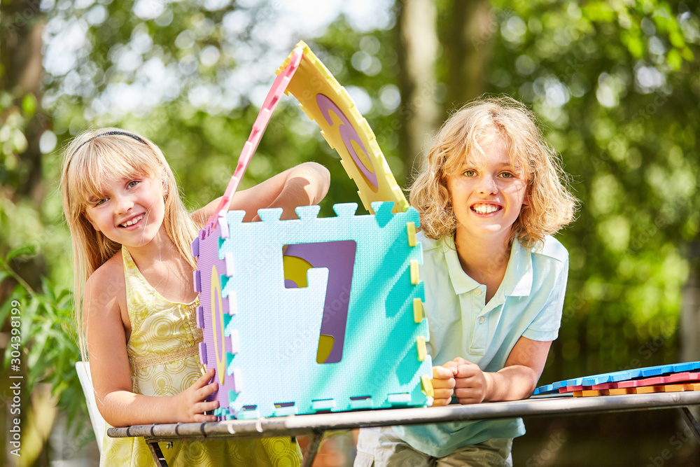 Children build a puzzle as a dream house fantasy Stock Photo | Adobe Stock