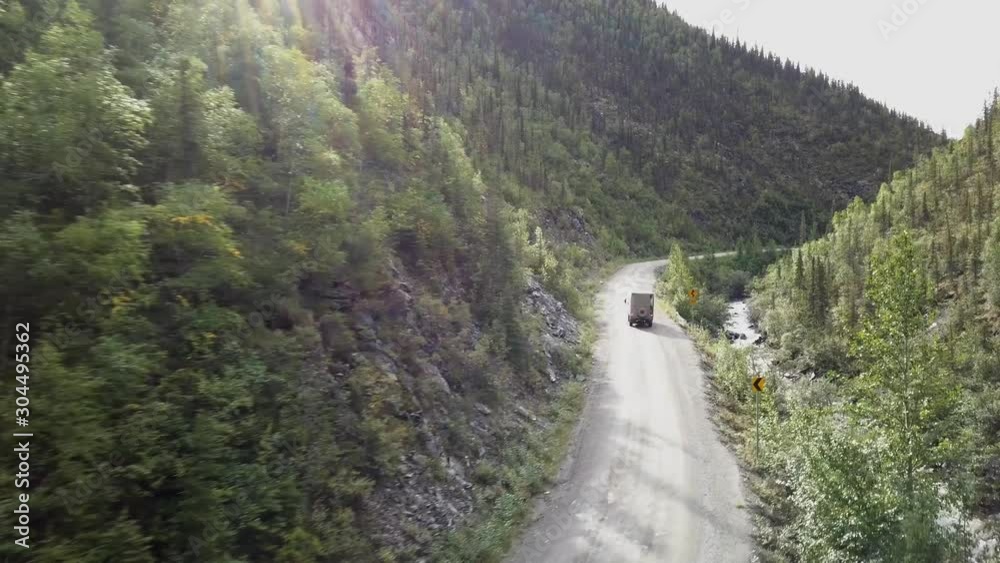Low flying aerial shot following an off road 4x4 camper van traveling ...