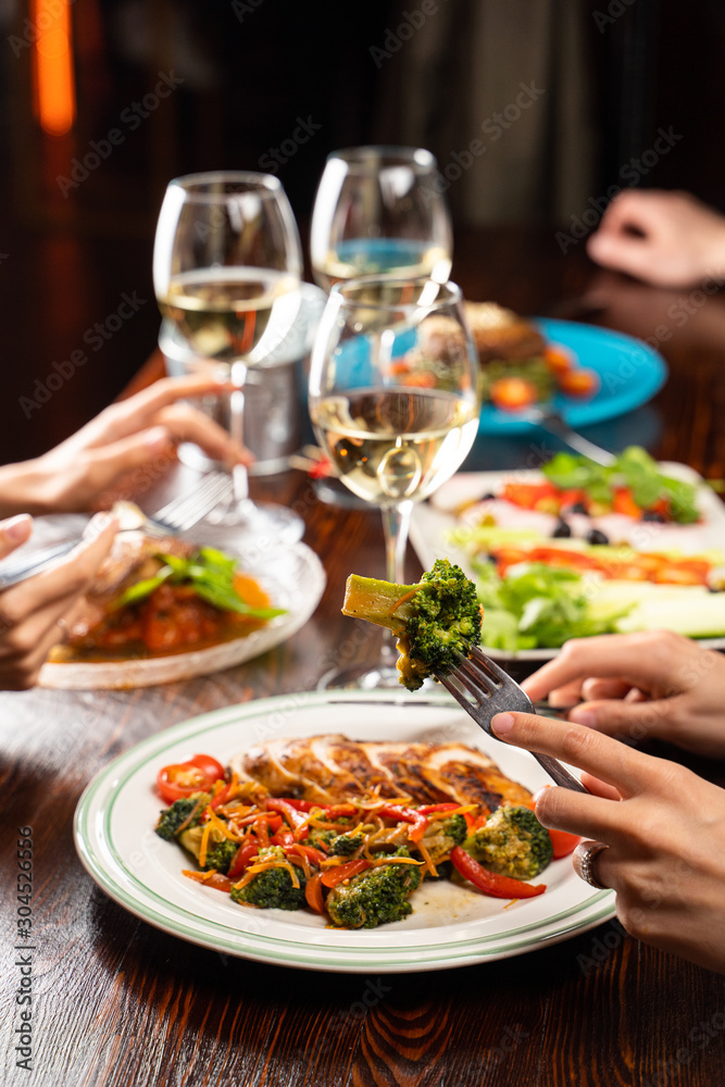 People having dinner in a restaurant with white wine and grilled ...