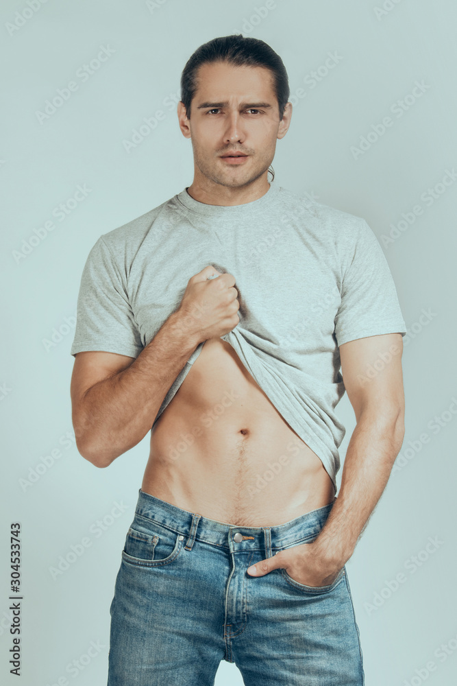 Muscle strong beautiful stripped male model in denim jeans on white ...