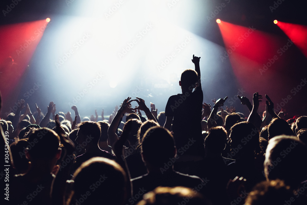 cheering crowd of unrecognized people at a rock music concert. crowd in ...