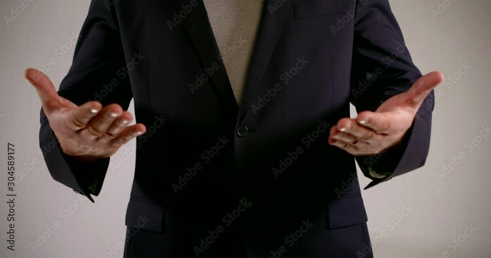 the middle plan of the male body in a dark suit. the man raises his ...