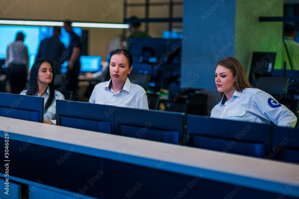Security guard monitoring modern CCTV cameras in a surveillance room ...