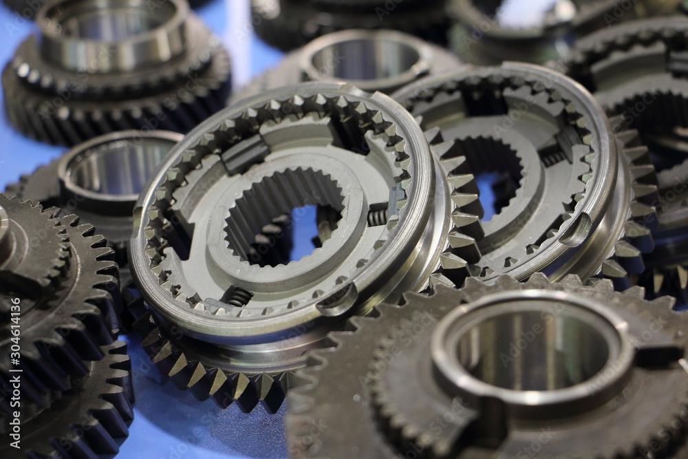 More car gearbox pinion cog wheels and synchronisers on blue background ...