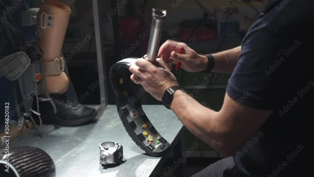 Production of a prosthetic leg. A man creates part of the leg. An ...