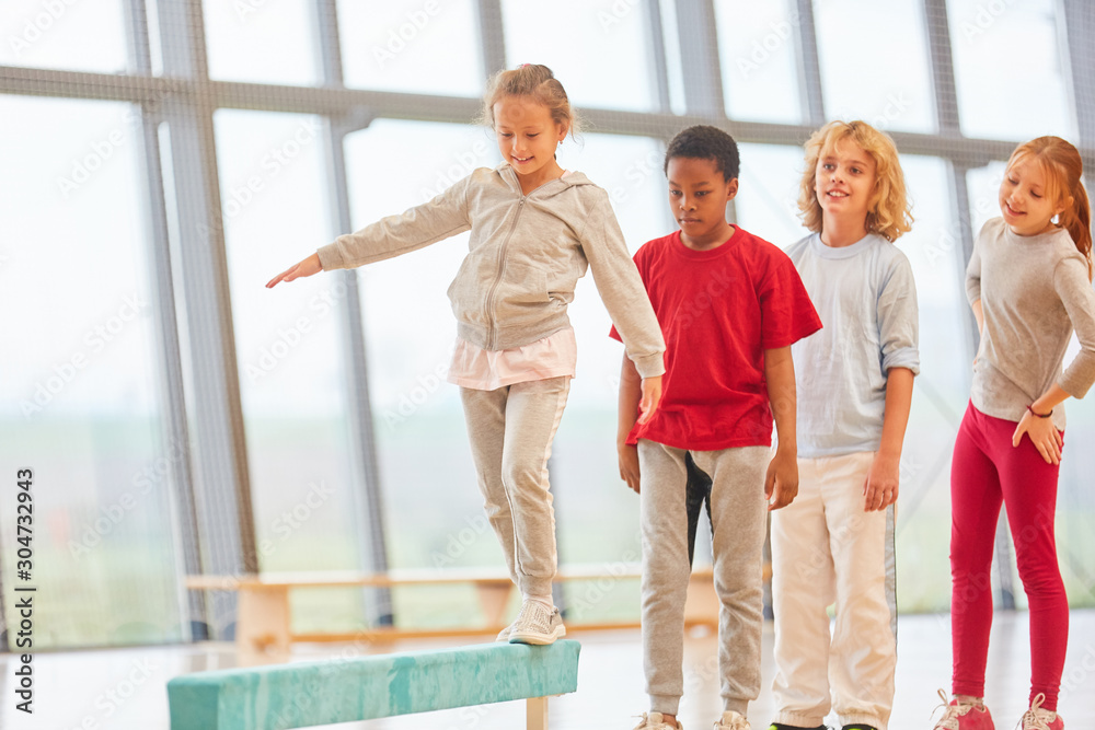 Pupils balance on a balance beam Stock Photo | Adobe Stock