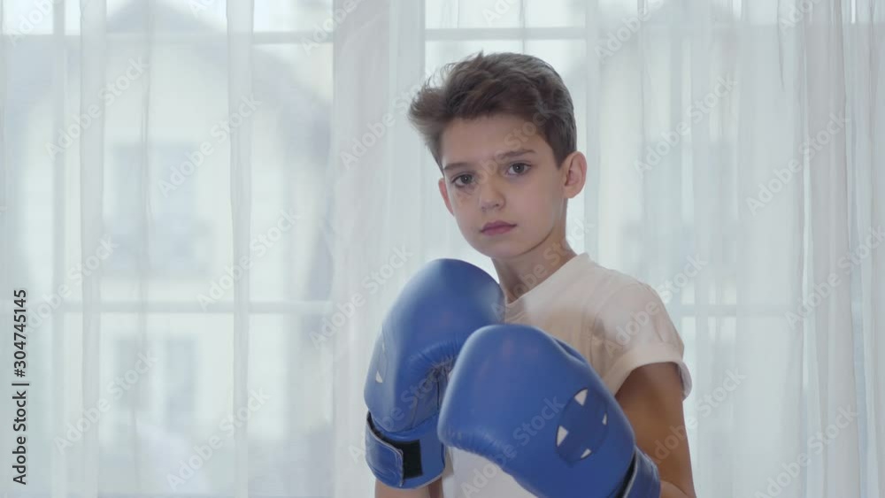 Close-up face of serious Caucasian boy standing in boxing stance ...