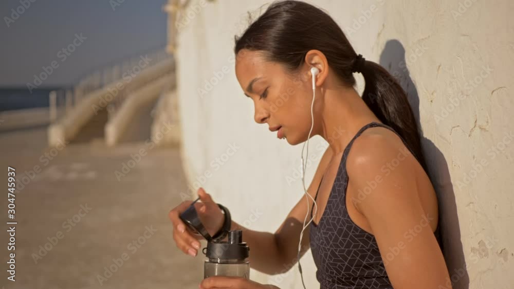 Exhausted young fitness woman with lip piercing wearing black tracksuit ...