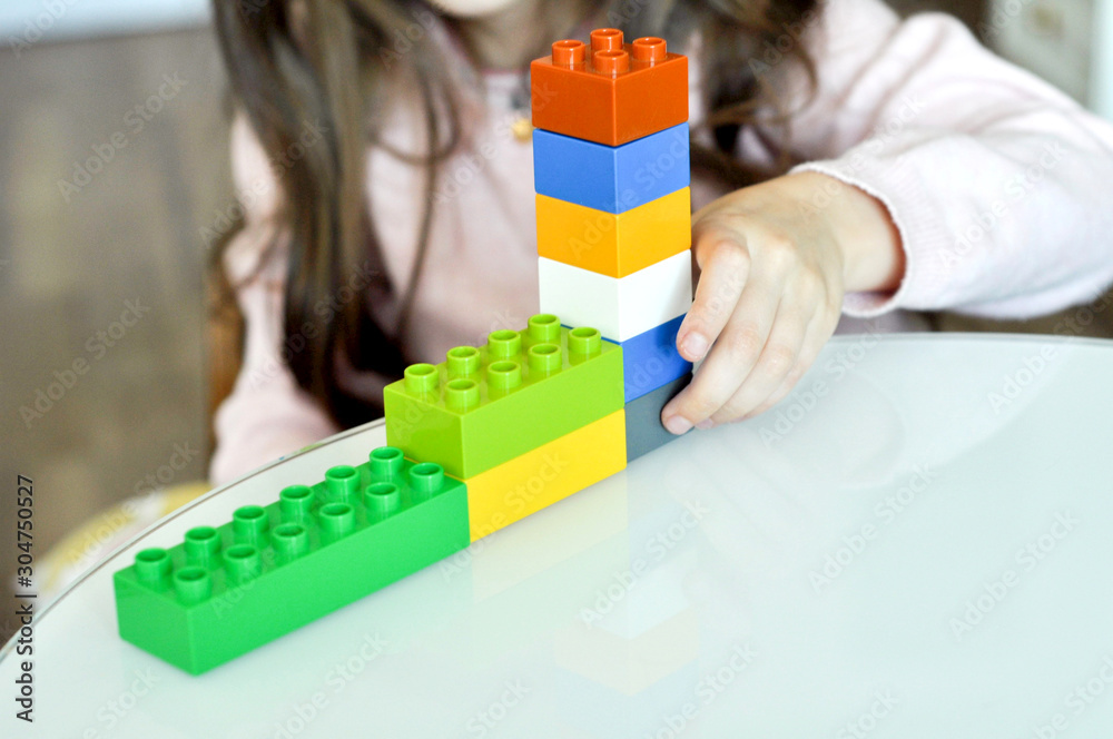 Child playing with plastic colorful blocks constructor at kindergarten ...