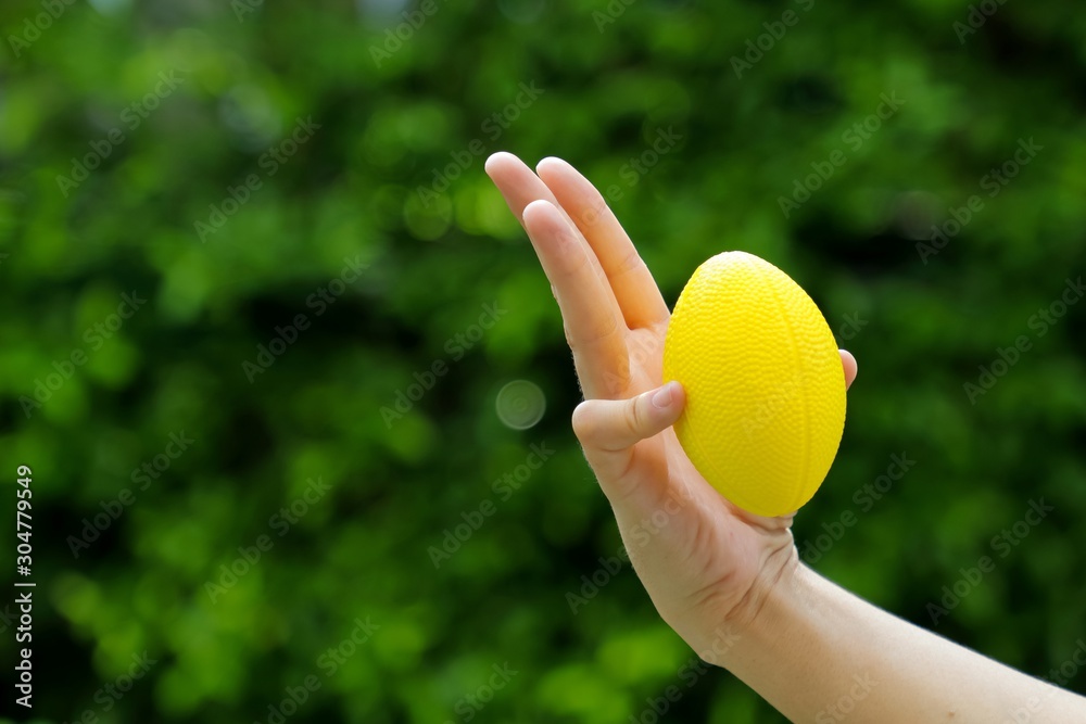 Hand holding stress ball and squeezing by thumb and little finger for ...