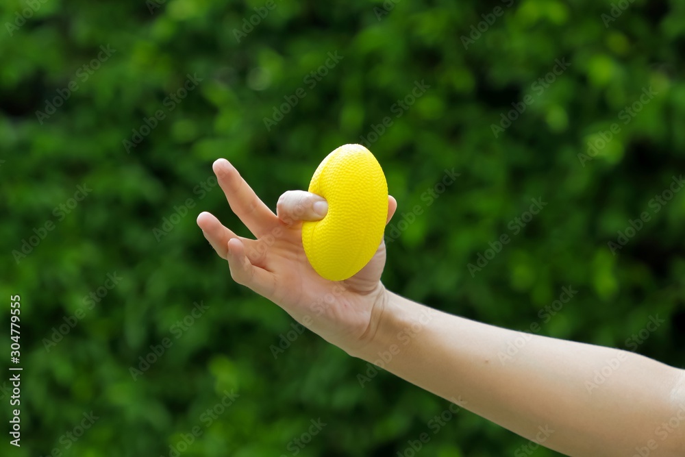 Hand holding stress ball and squeezing by thumb and forefinger for ...