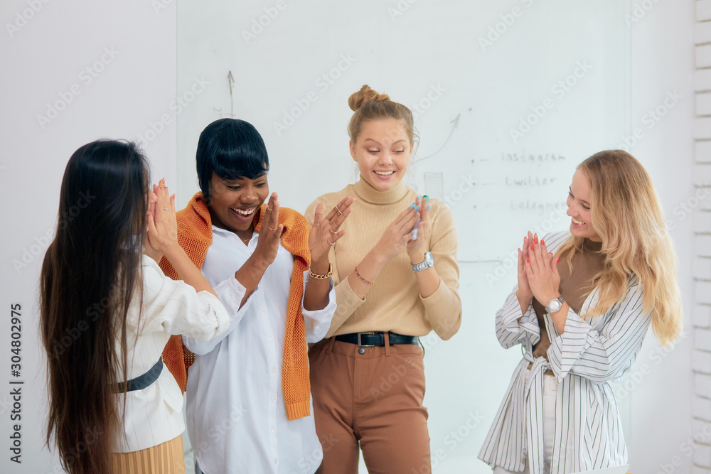 Young ladies clapping hands, good job of four diverse female working on ...