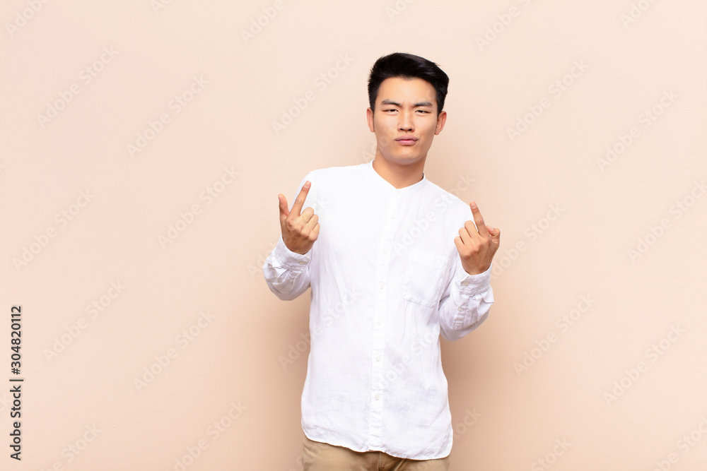 young chinese man with a bad attitude looking proud and aggressive ...