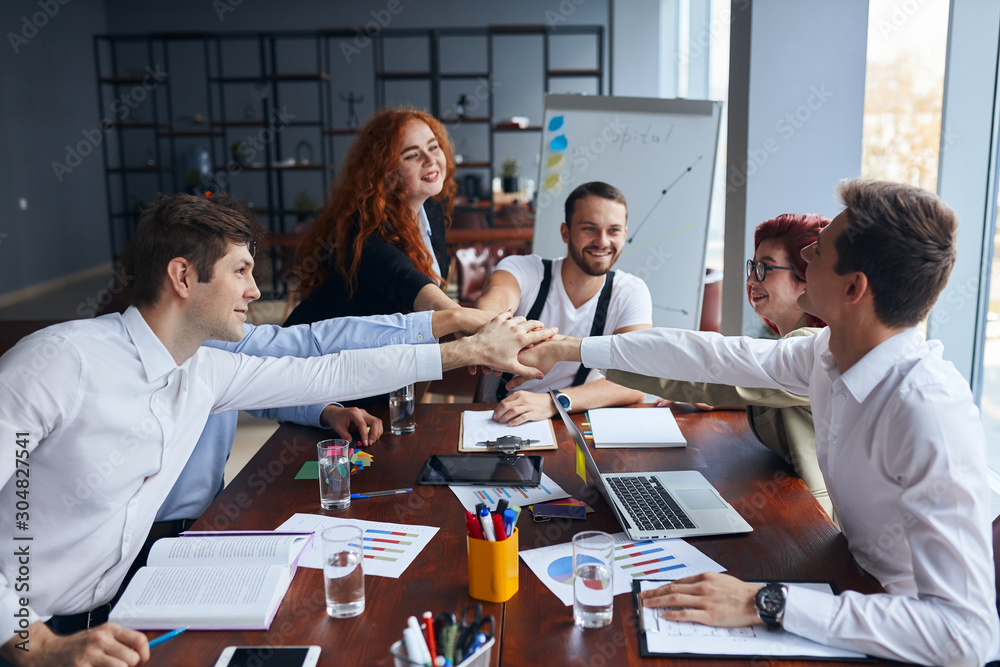 Solving problems as one team. Caucasian young team of male and female ...