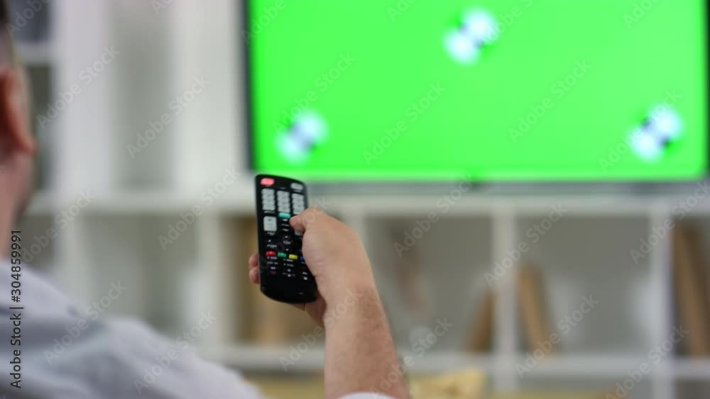 Tilt up rack focused shot of man sitting on couch in the living room ...