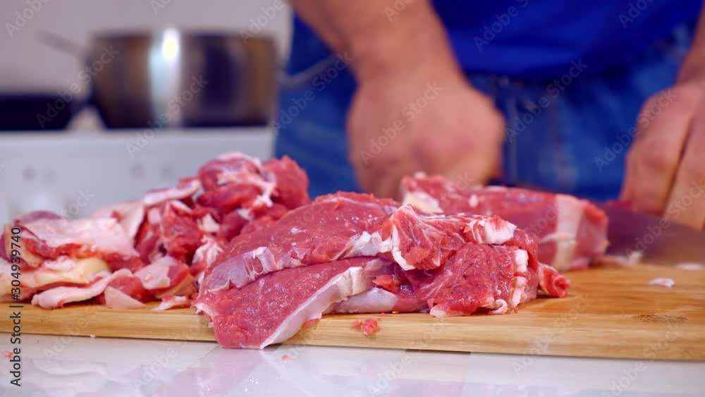 Human hands cut meat with a knife. Butcher cuts meat on a cutting Board ...