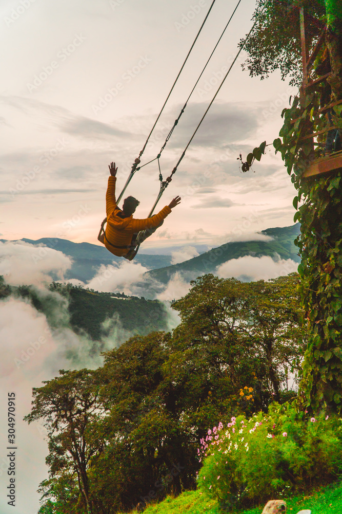 Man on giant swing Ecuador. Tourist having fun swinging on Giant Swing ...