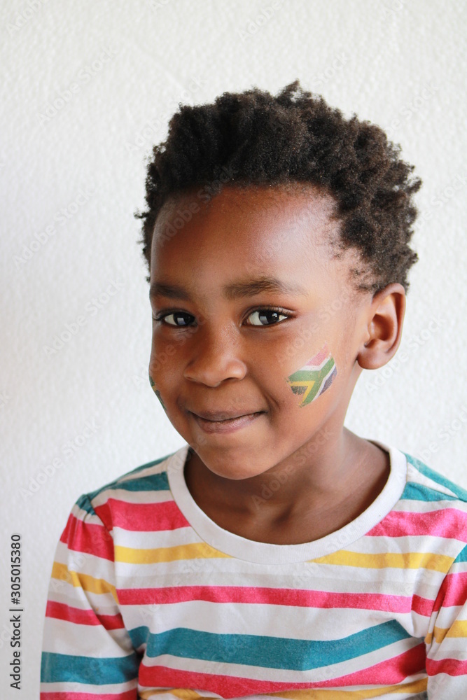 young african child with afro and face paint of the south african flag ...