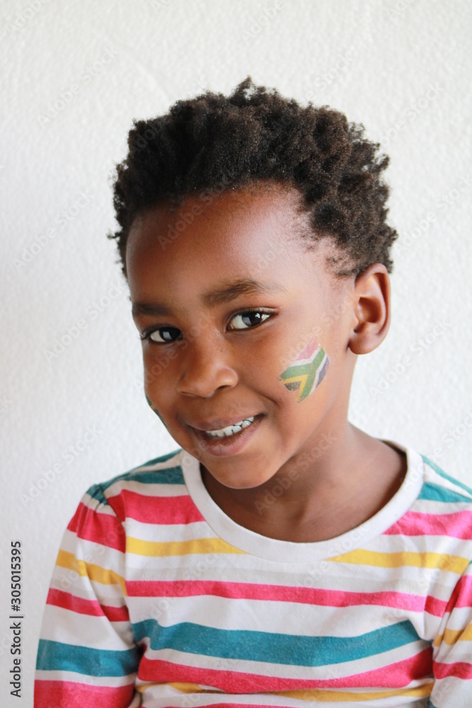 young african child with afro and face paint of the south african flag ...